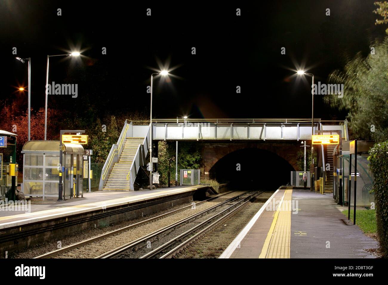 Quiet un-manned UK country railway station and bridge at night Stock ...