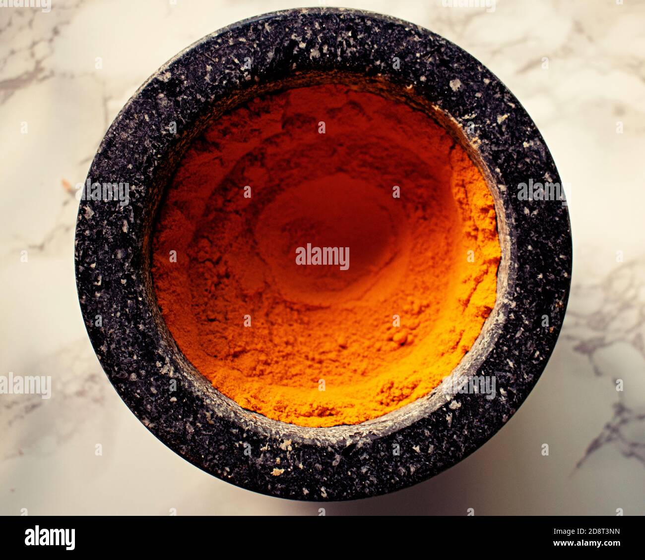 Vivid orange from Turmeric spice in dark stone mortar and pestle Stock ...