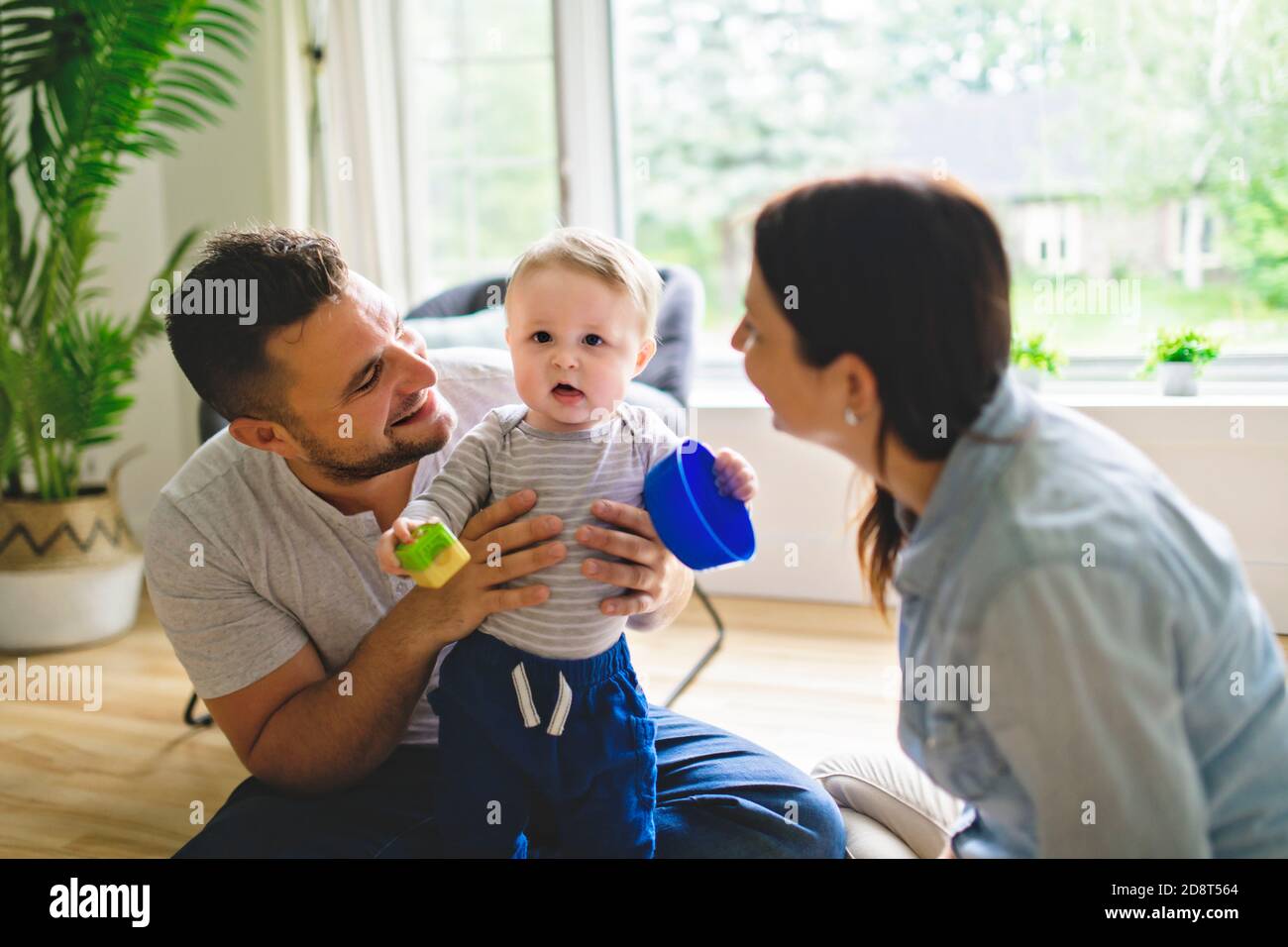 Couple in living room with baby toys Stock Photo - Alamy