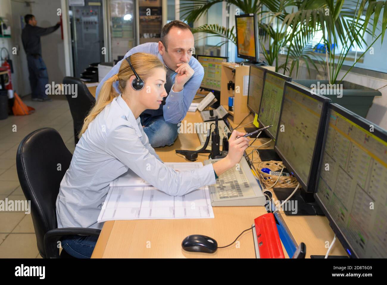 workers assessing information in computer control station Stock Photo ...
