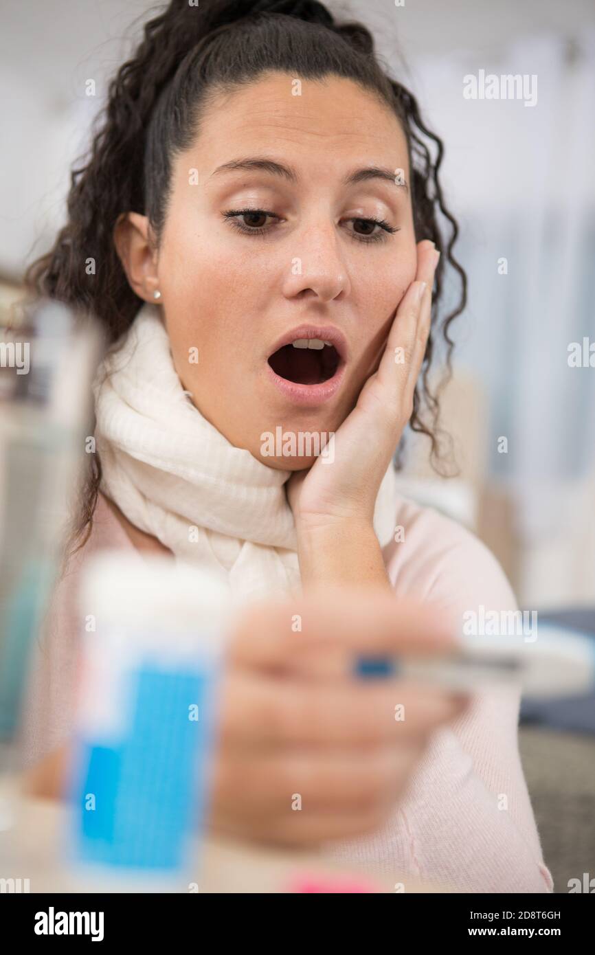 woman looking in shock at the thermometer Stock Photo - Alamy