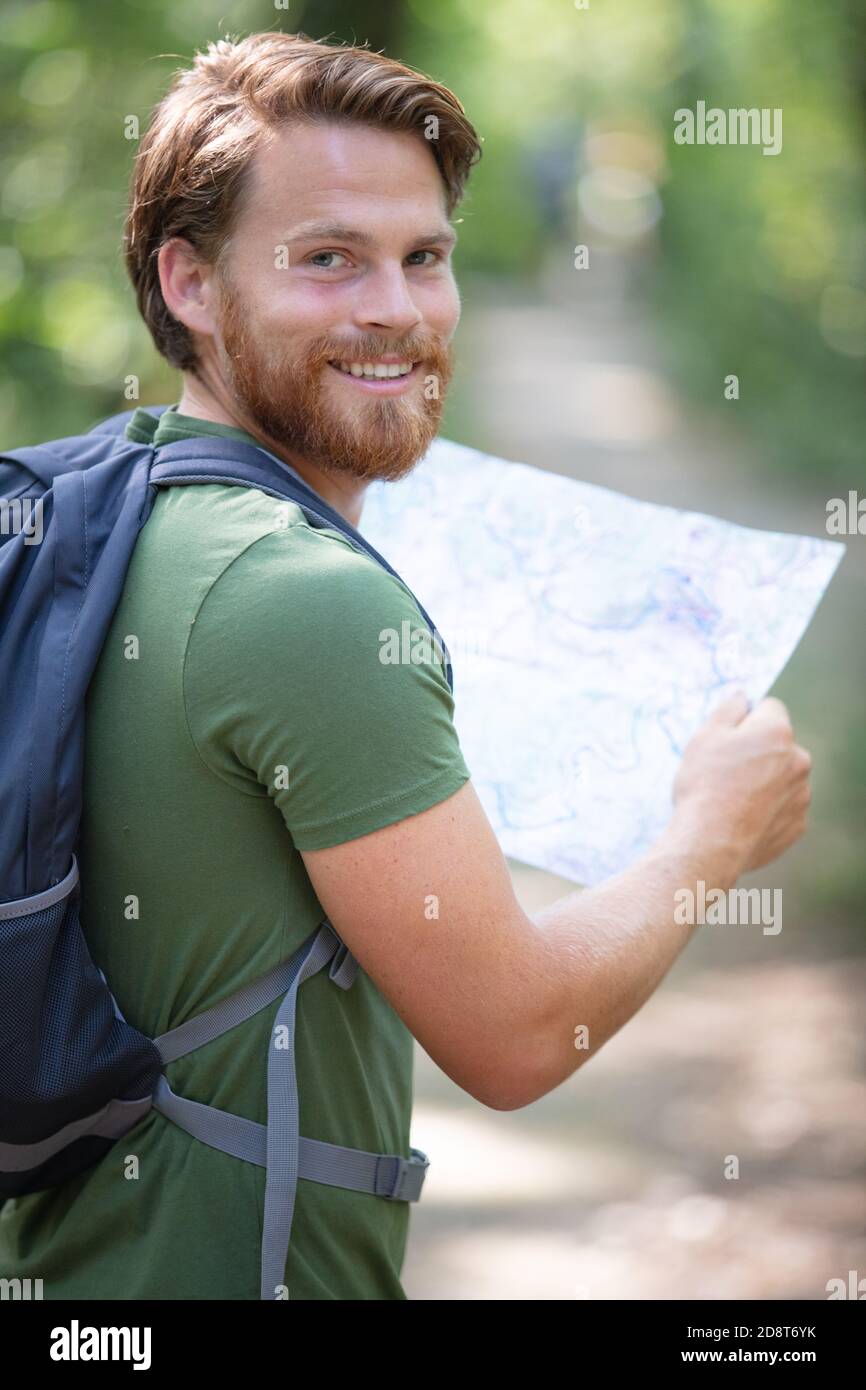 happy man with backpack and map searching directions t map Stock Photo ...
