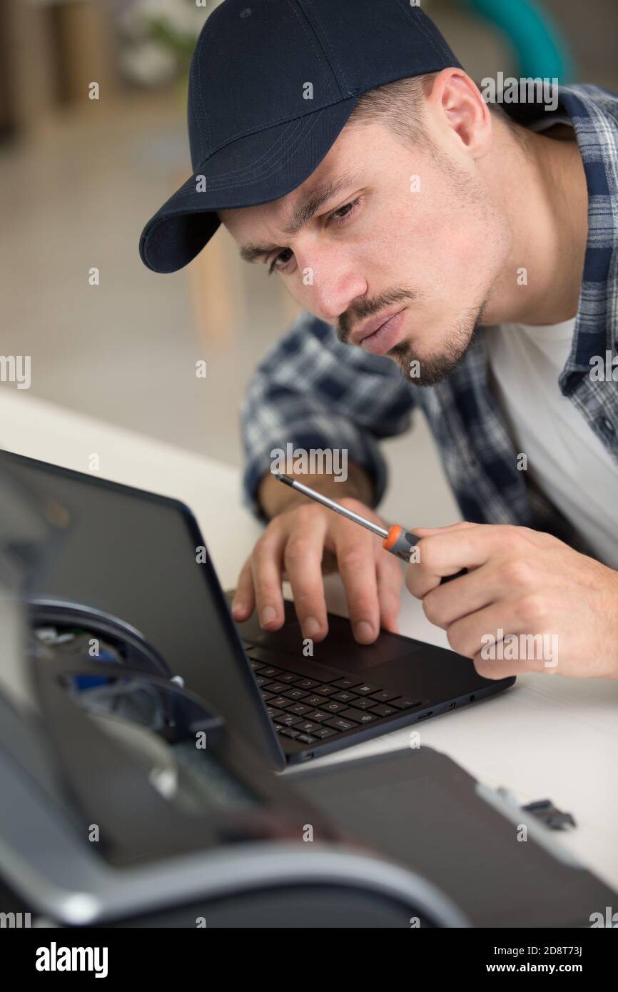 male worker holds a screwdriver for fixing printer Stock Photo - Alamy