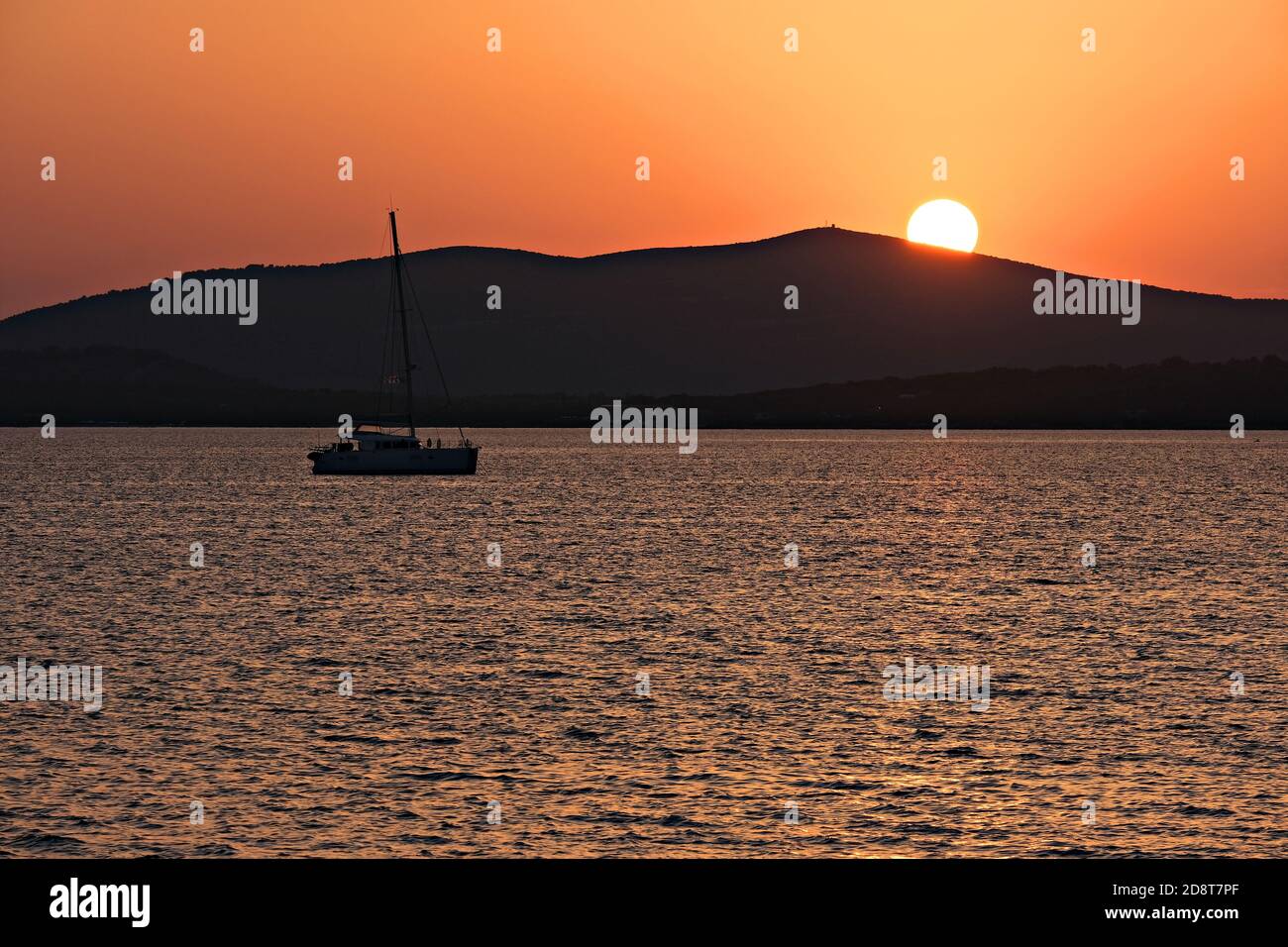 Sailboat on quiet sea at the sunset Stock Photo - Alamy