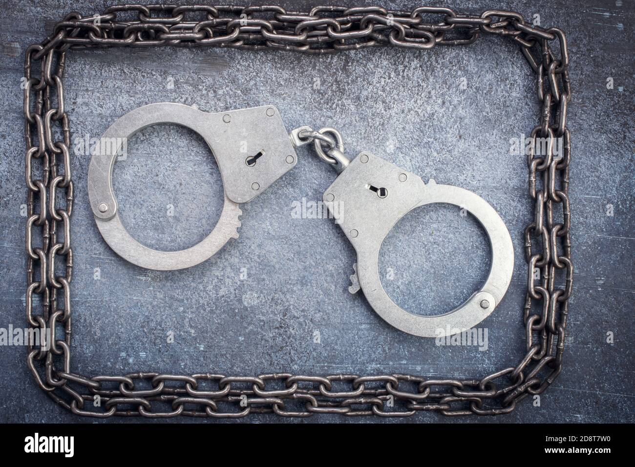 Handcuffs with chain around Stock Photo - Alamy