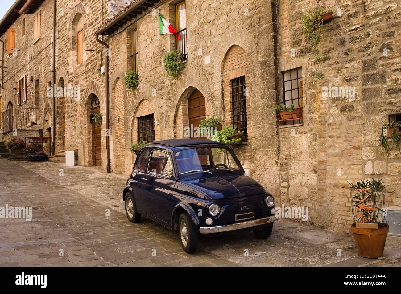 An alley of an Italian medieval village with an old car parked (Gubbio ...