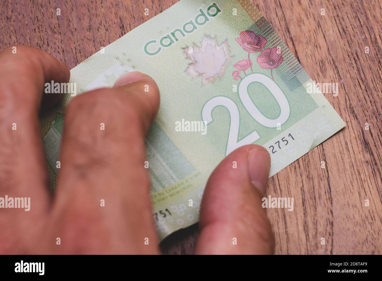 Persons hand giving the Currency of the Canada - One green twenty ...