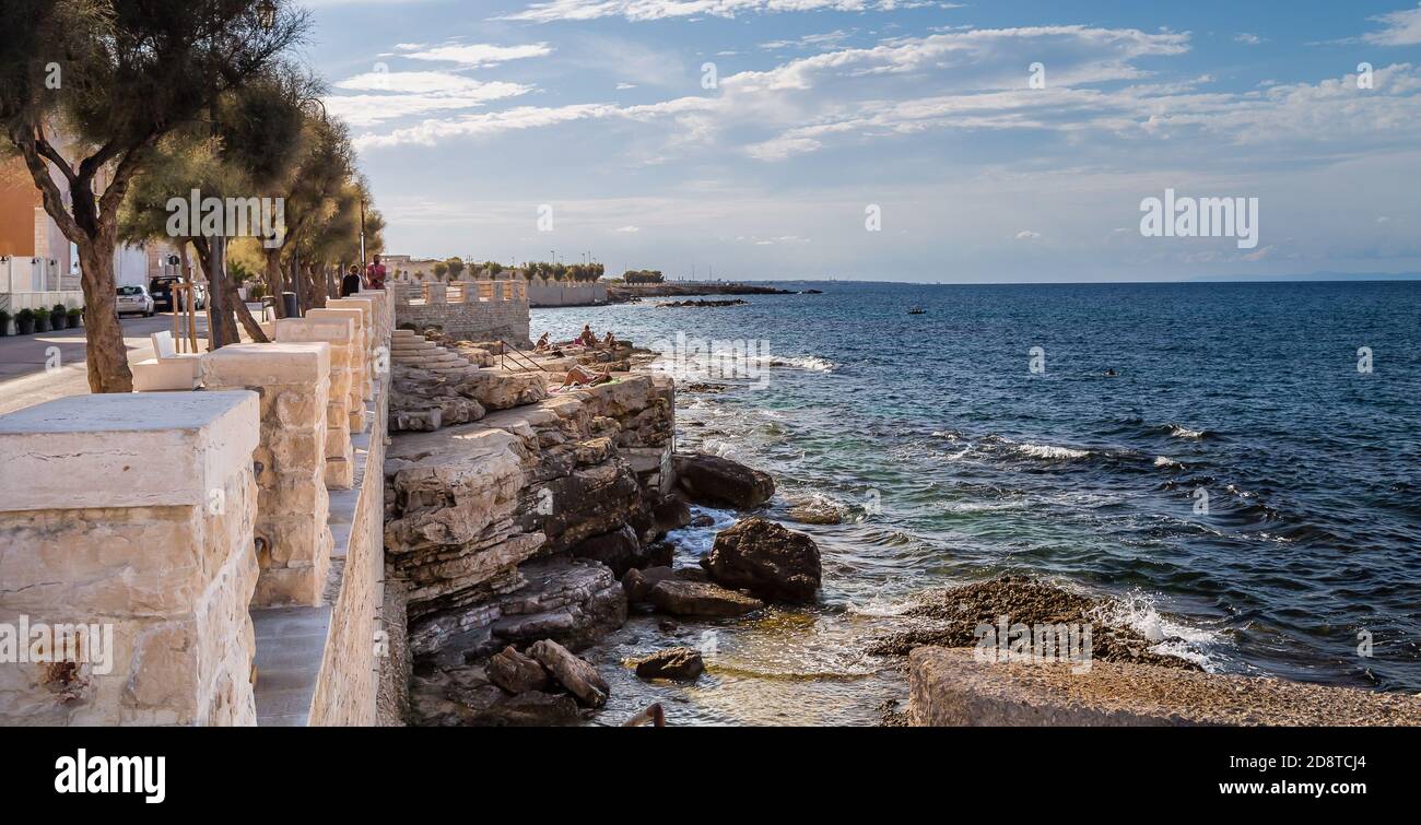 people sunbathing on the rocks in Italy Stock Photo - Alamy