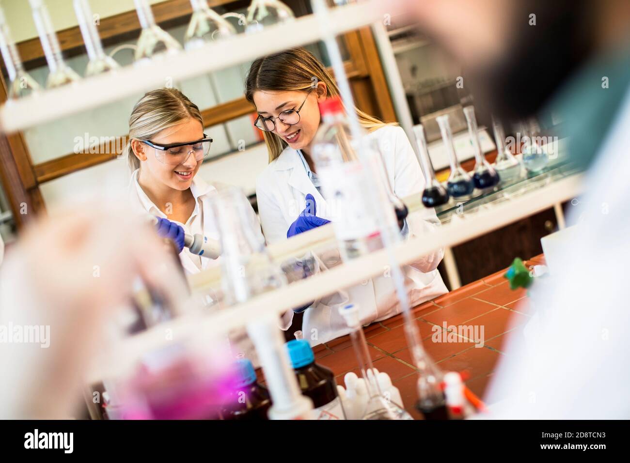 Cute female researchers in white lab coat working in the laboratory ...