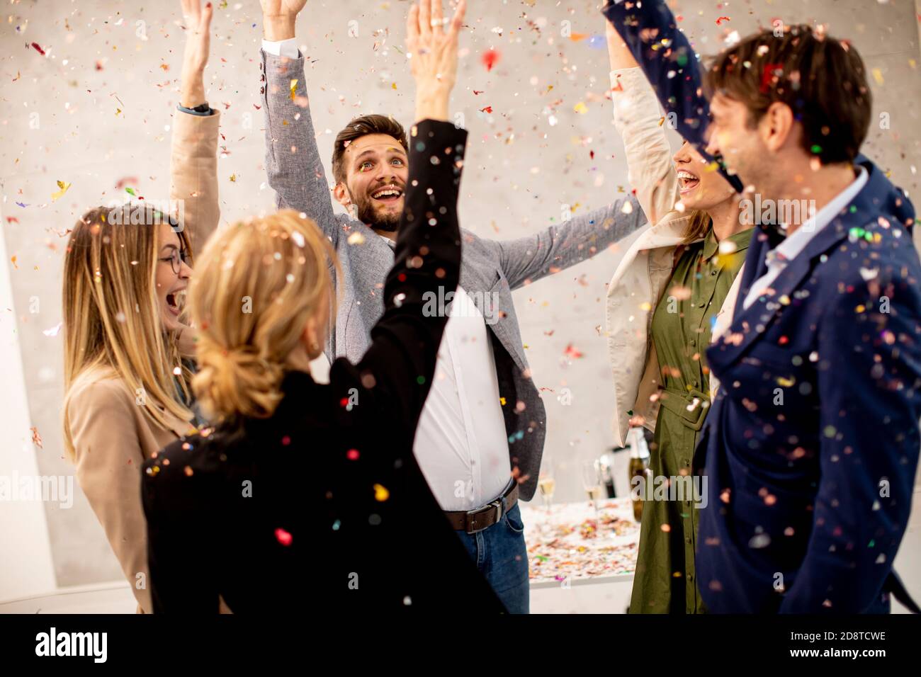 Group of excited business people celebrating and toasting with confetti ...