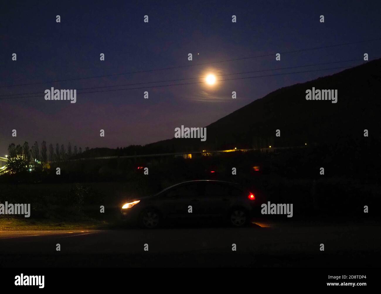 silhouette of a car with the moon behind Stock Photo - Alamy