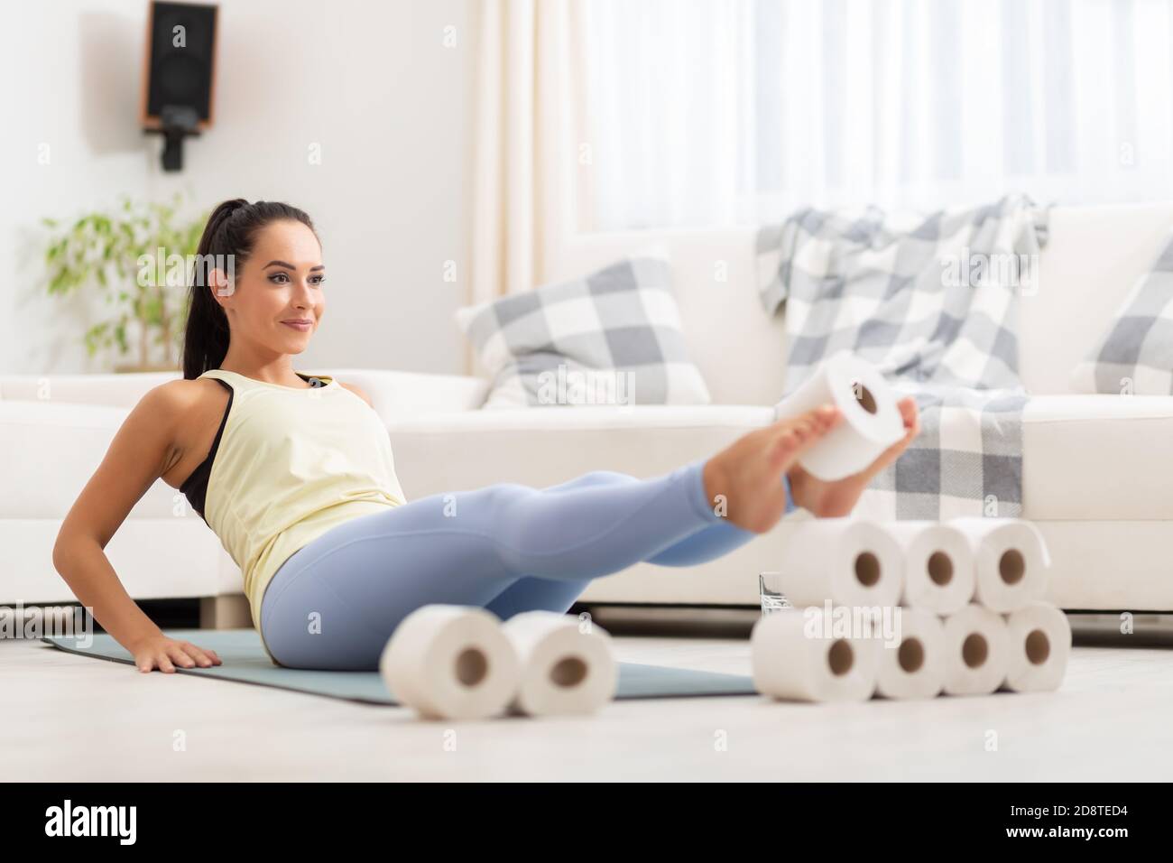 Creative abs workout of a beautiful brunette making a toilet paper ...