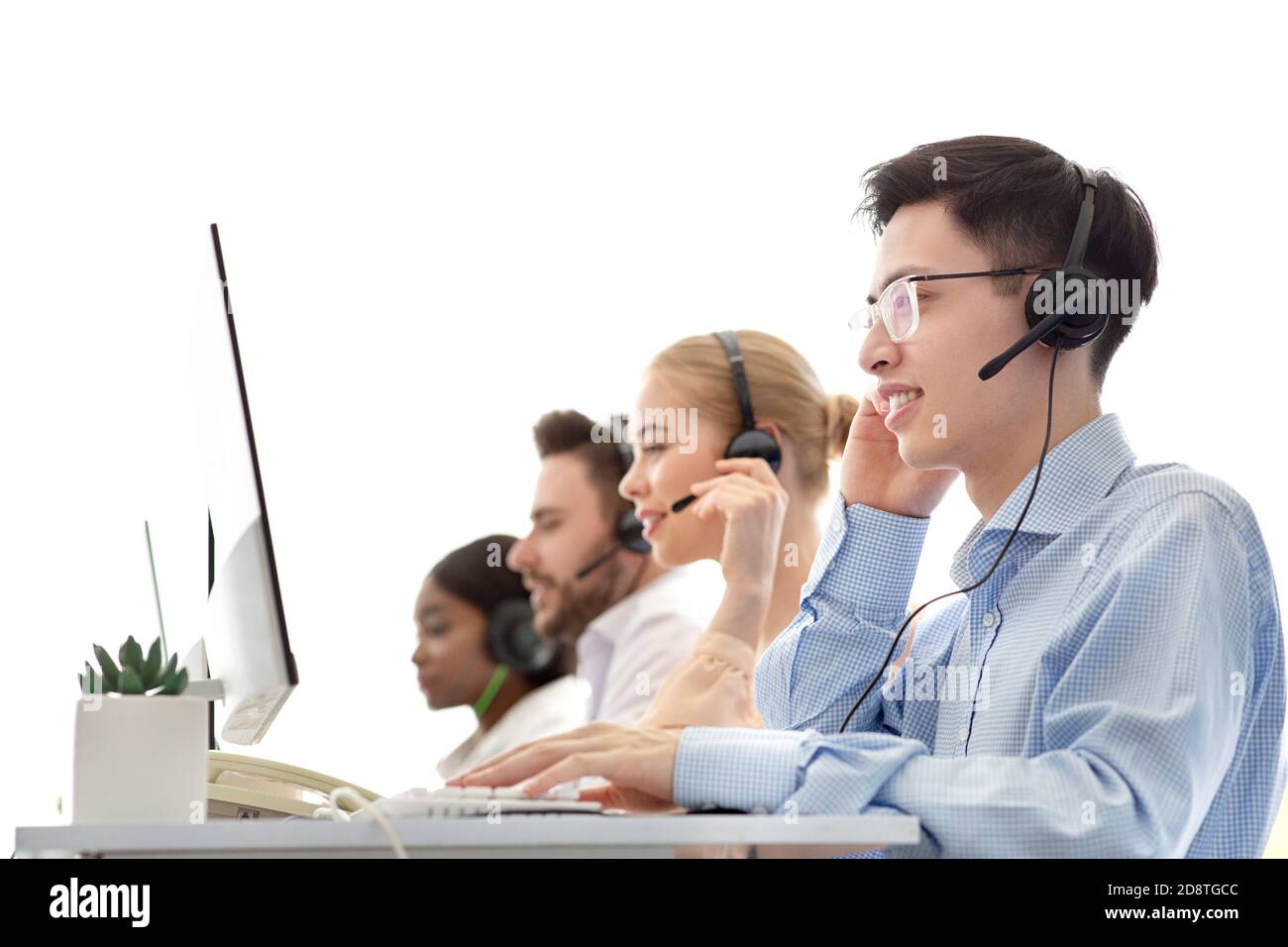 Diverse team of call centre operators working with computers at modern ...
