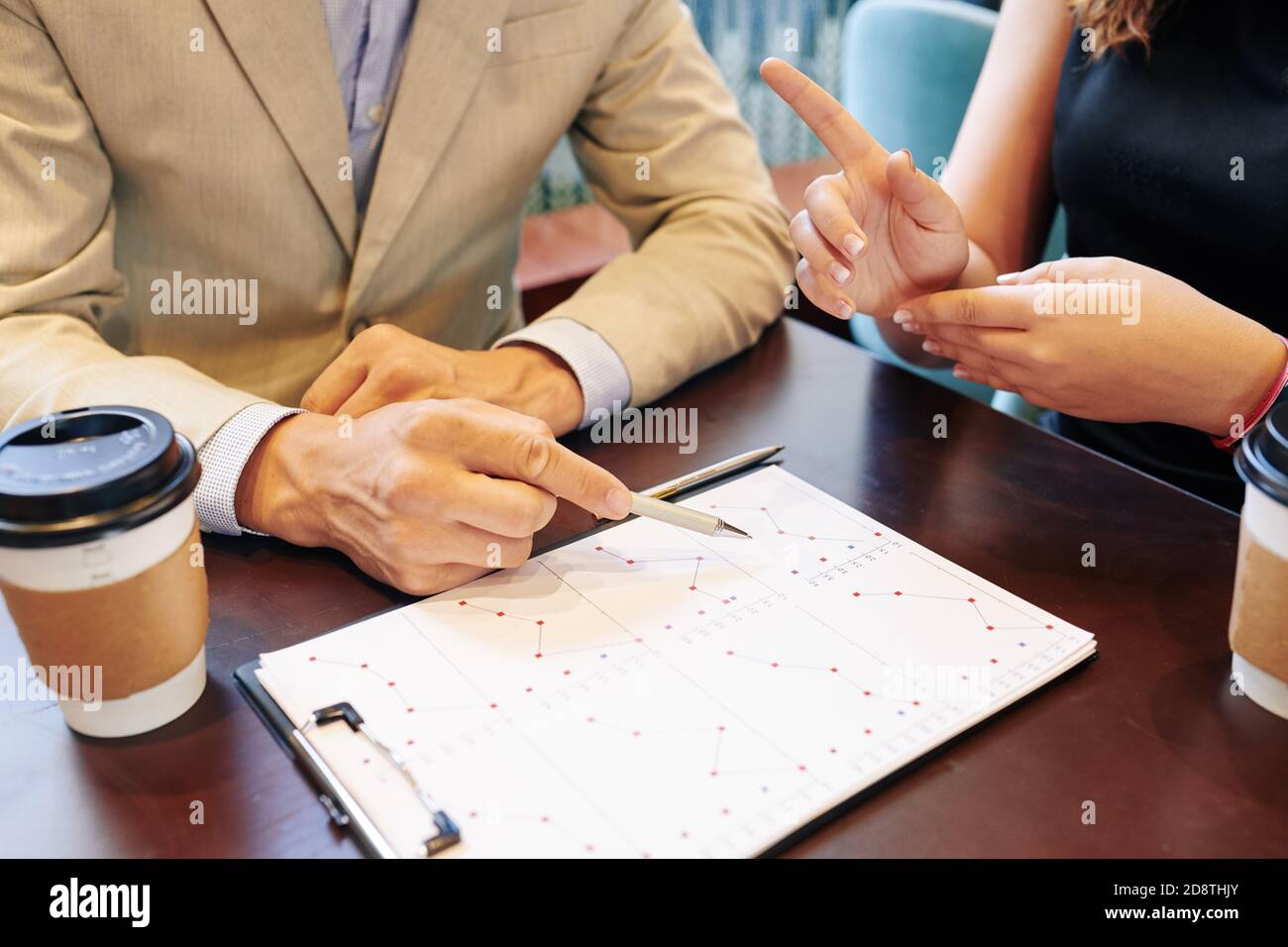 Business people analyzing chart Stock Photo - Alamy