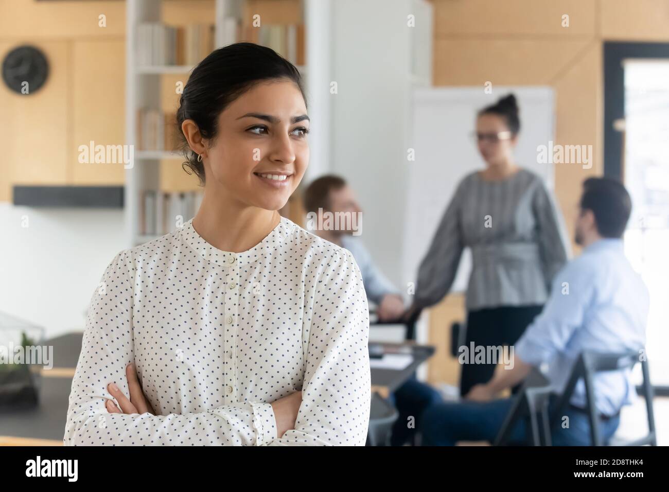 Confident smiling indian ethnicity female leader thinking about ...