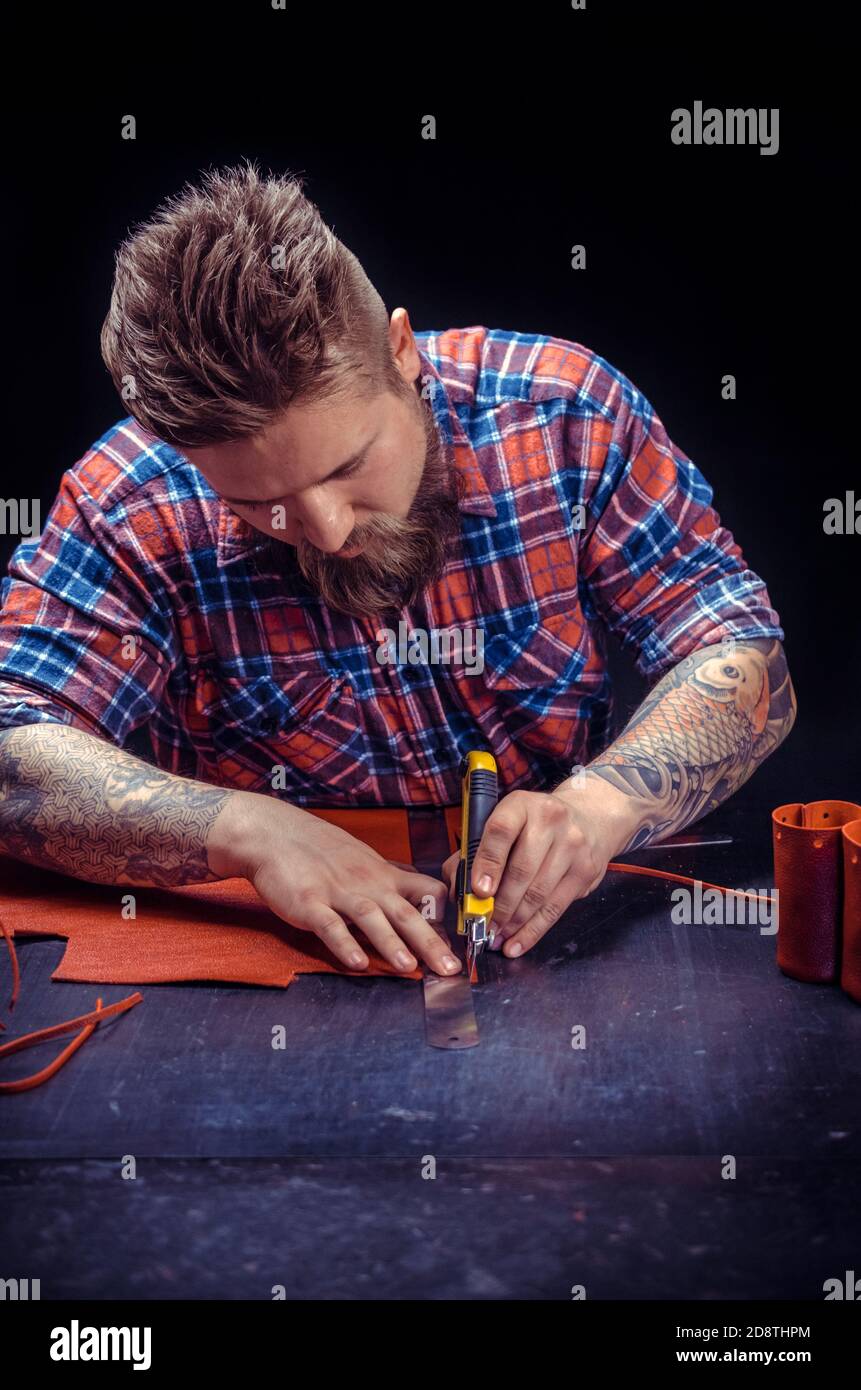 Artist working with leather creating leatherwork Stock Photo - Alamy