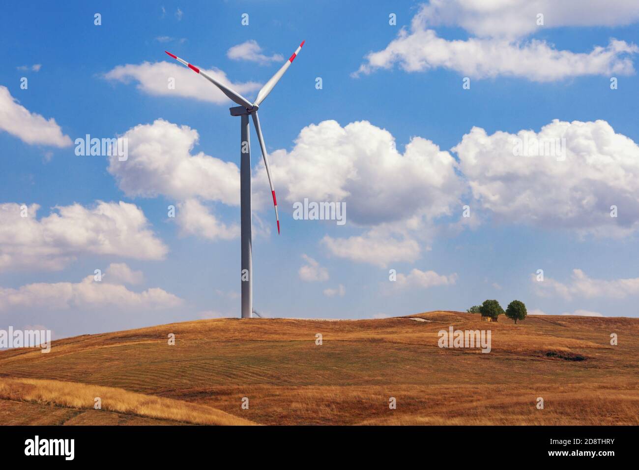 One windmill on the background of yellow grassland and blue sky with ...