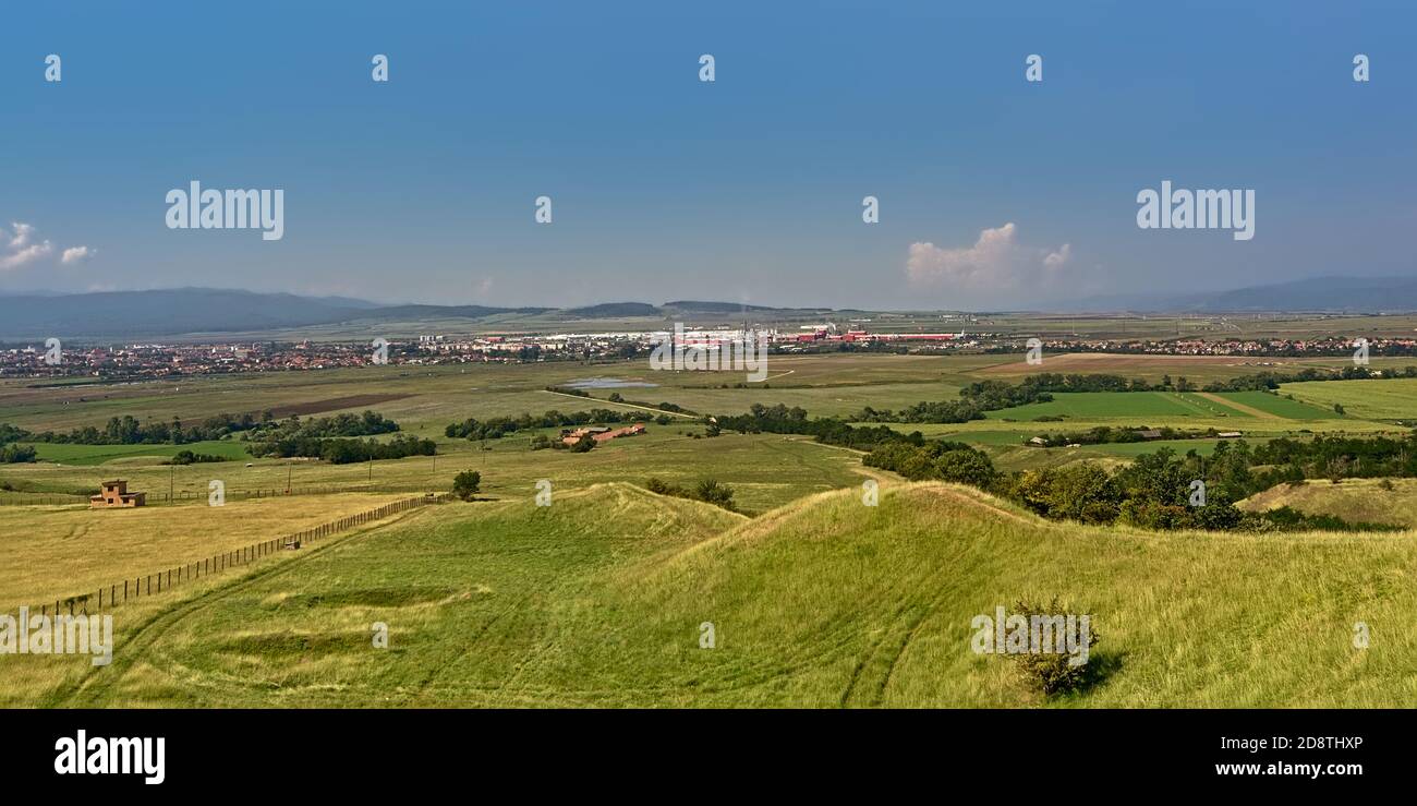 Transylvanian landscape with green fields and city, industrial ...