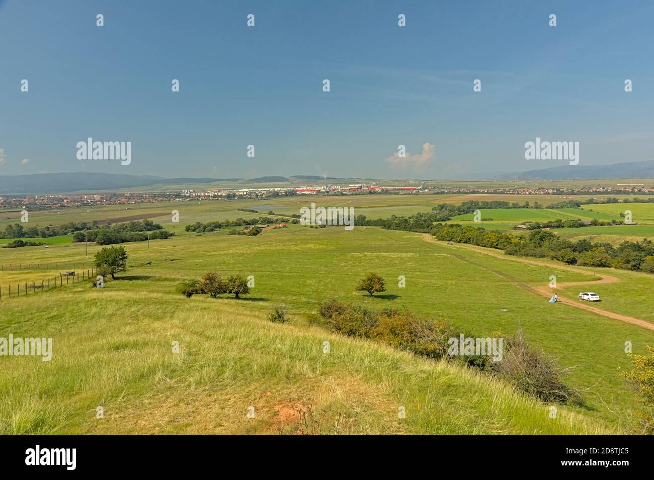 Transylvanian landscape with green fields and city, industrial ...