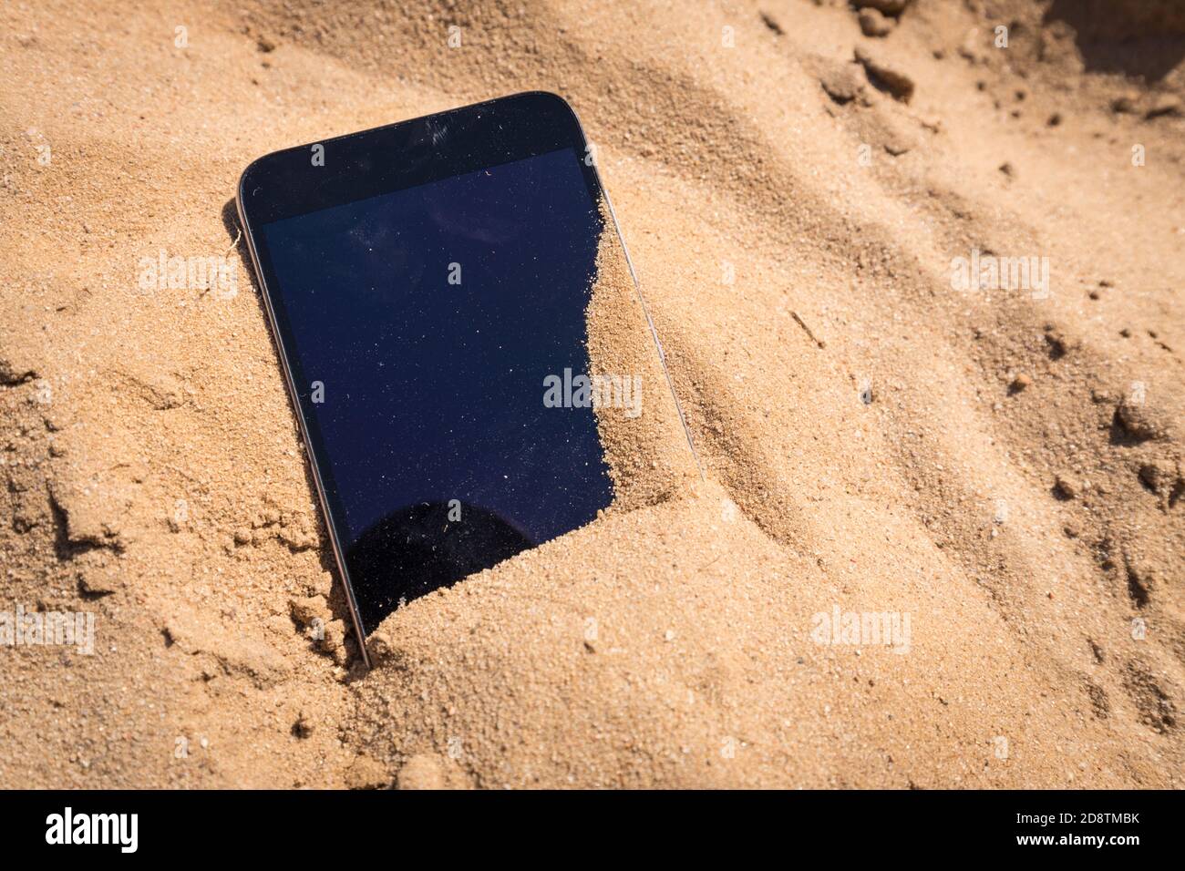 mobile phone lost and lying in the sand Stock Photo - Alamy