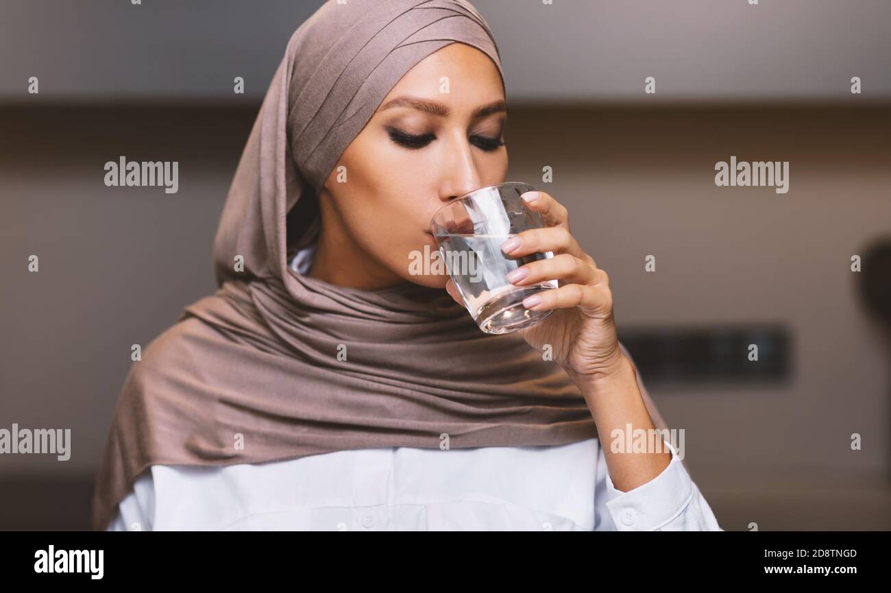 Muslim Woman Drinking Water Standing In Modern Kitchen At Home Stock ...