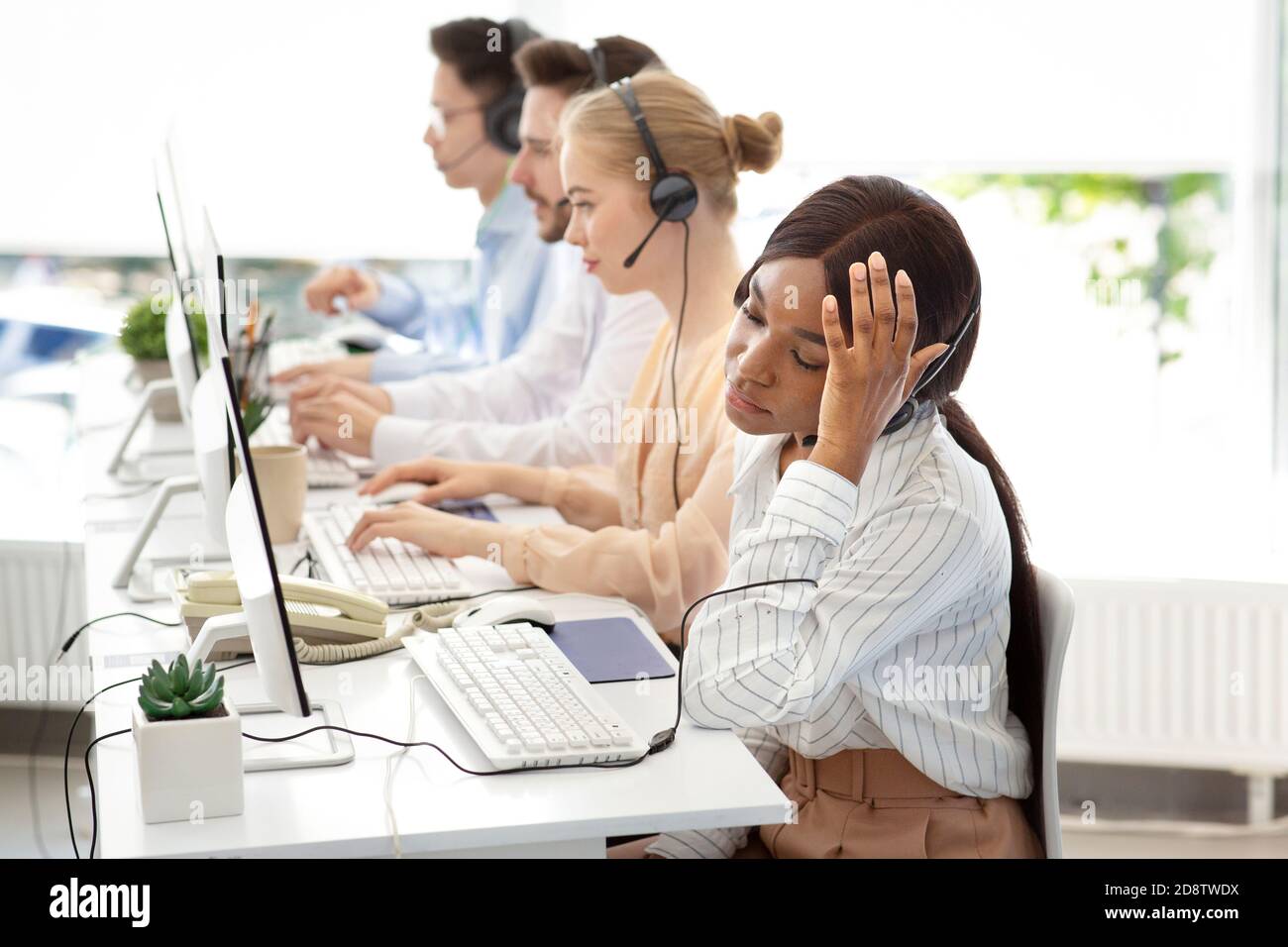 African American female helpline operator feeling exhausted after ...