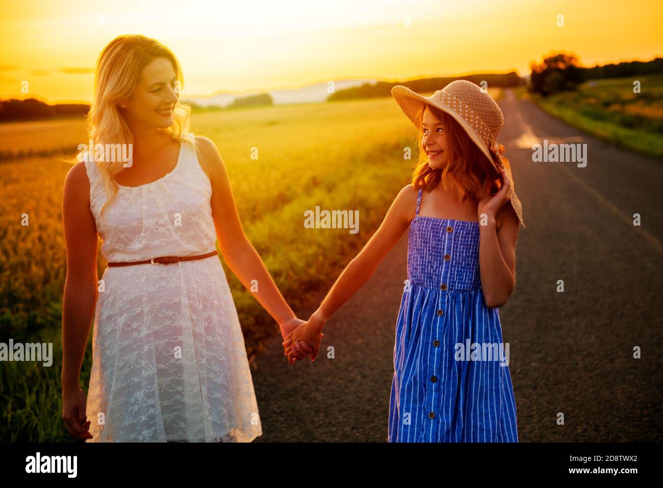happy family at sunset. Mother and daughter having fun and playing in ...