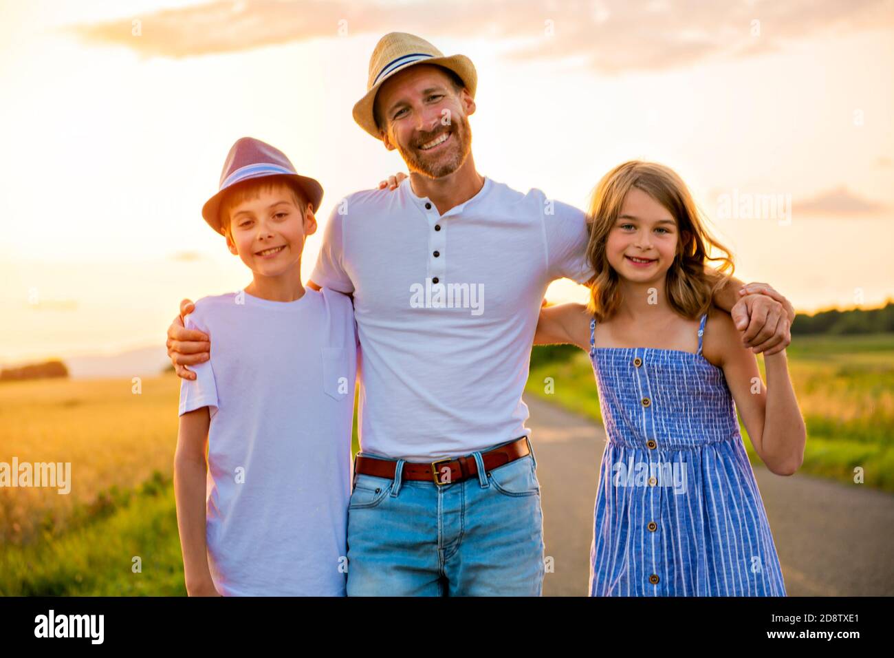 A happy family at sunset. father daughter and son having fun and ...