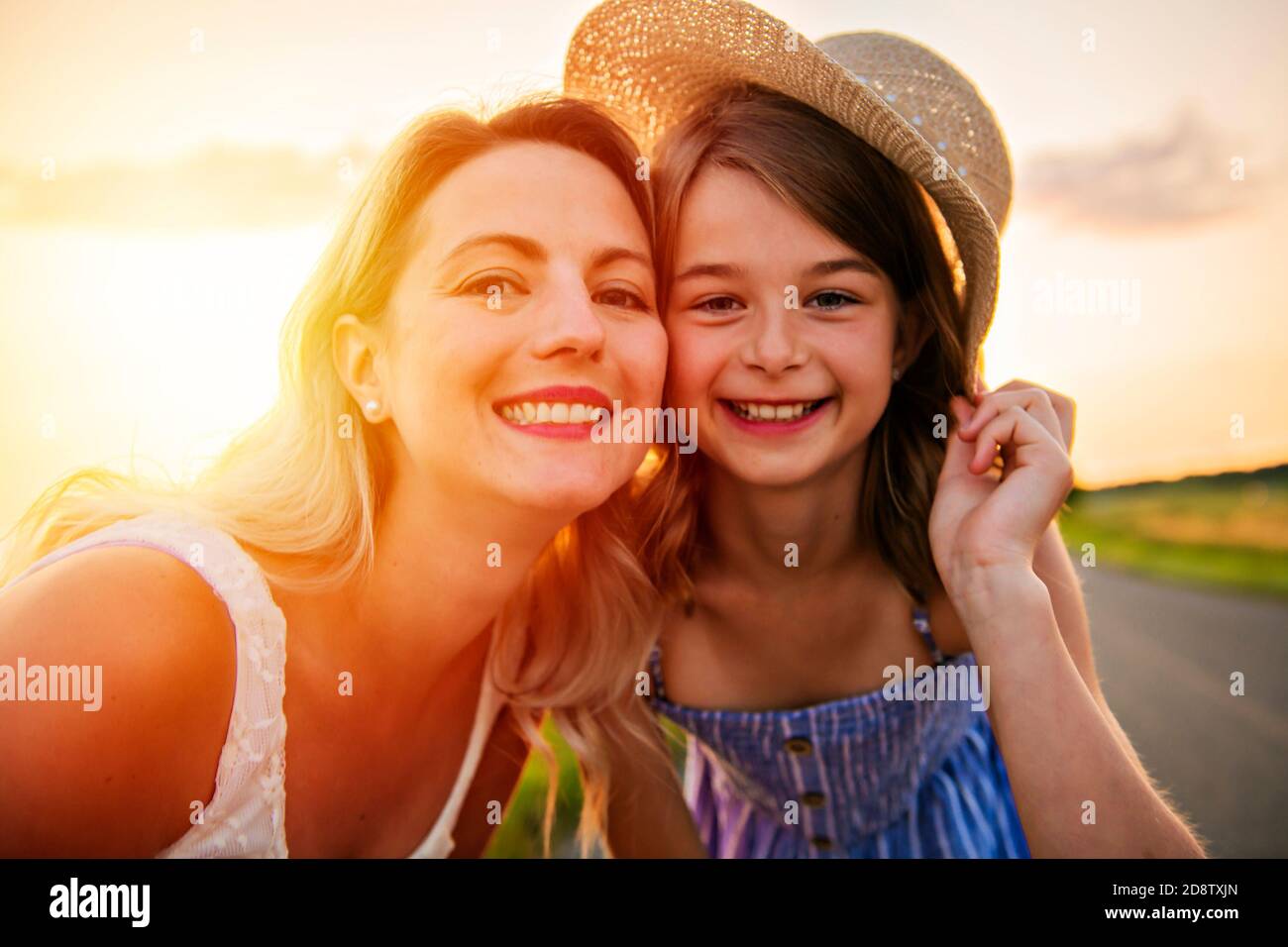 happy family at sunset. Mother and daughter having fun and playing in ...