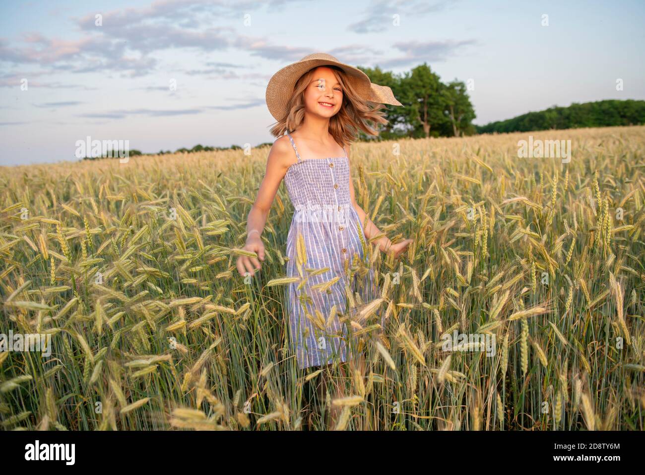 Child girl on a hay field at the sunset Stock Photo - Alamy