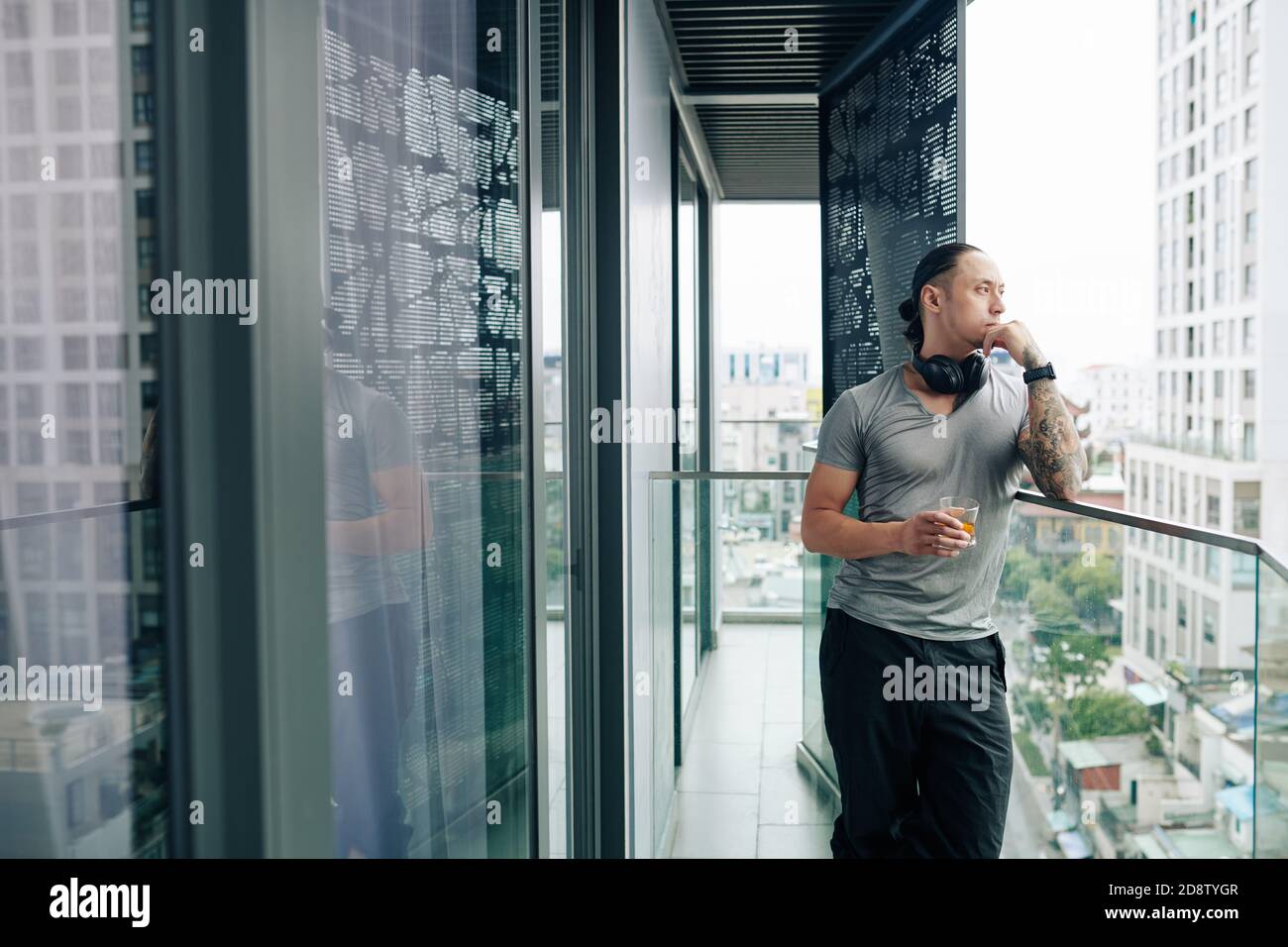 Pensive man standing on balcony Stock Photo - Alamy