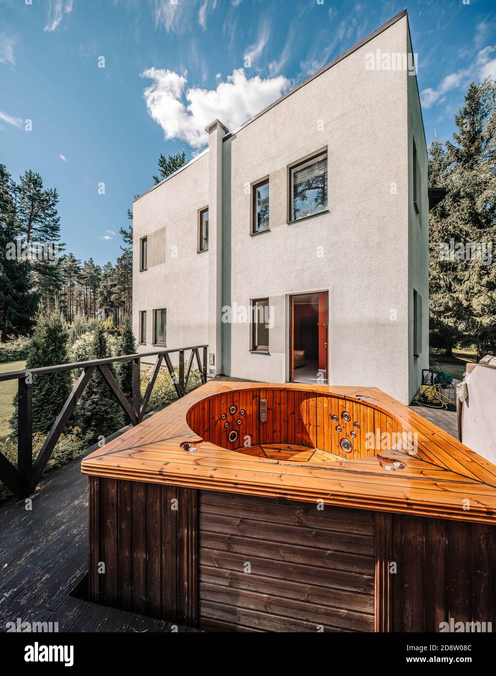 Modern exterior of luxury private house. Wooden bath tub on terrace ...