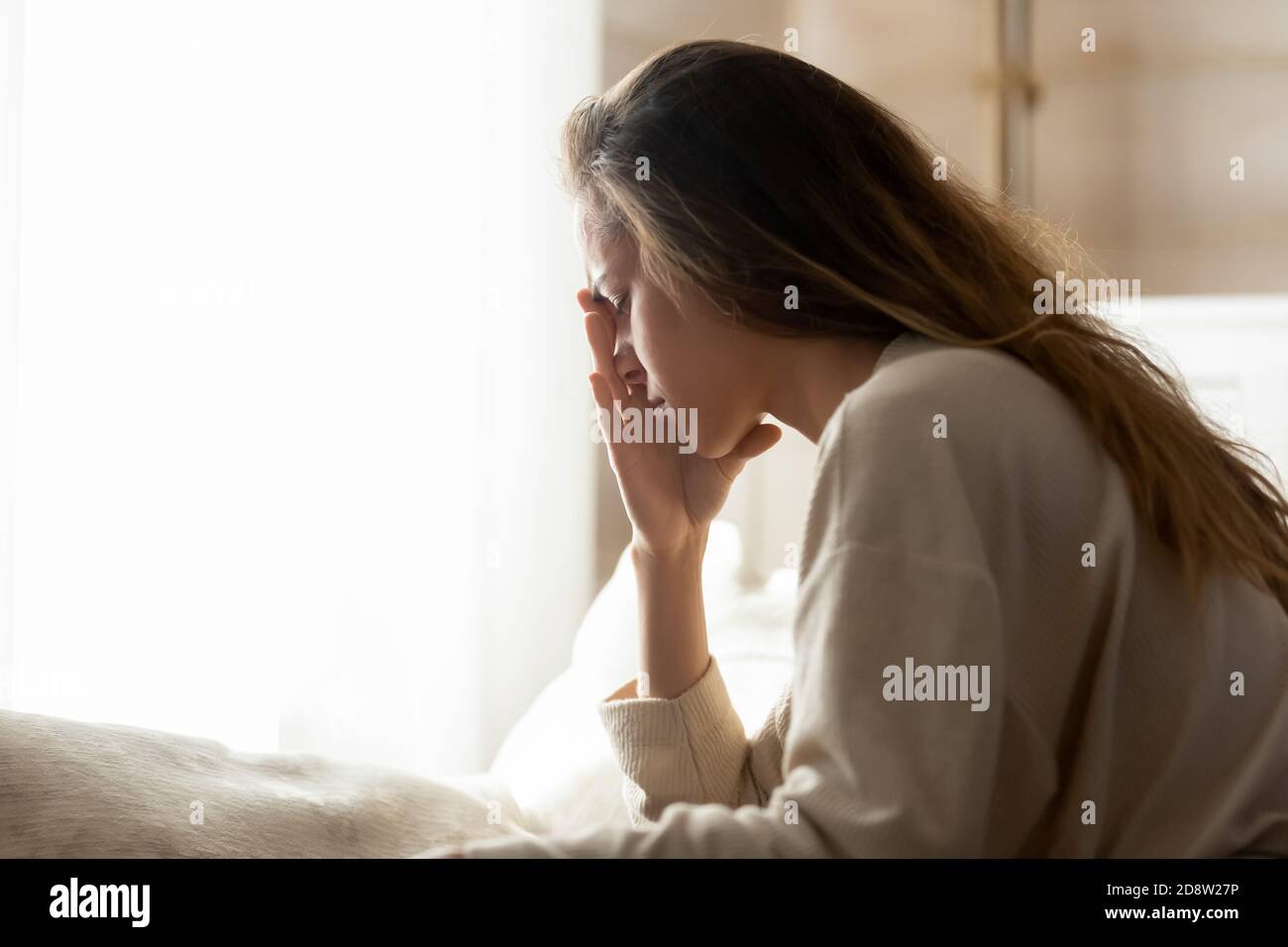 Depressed young woman sitting at home alone crying in silence Stock ...