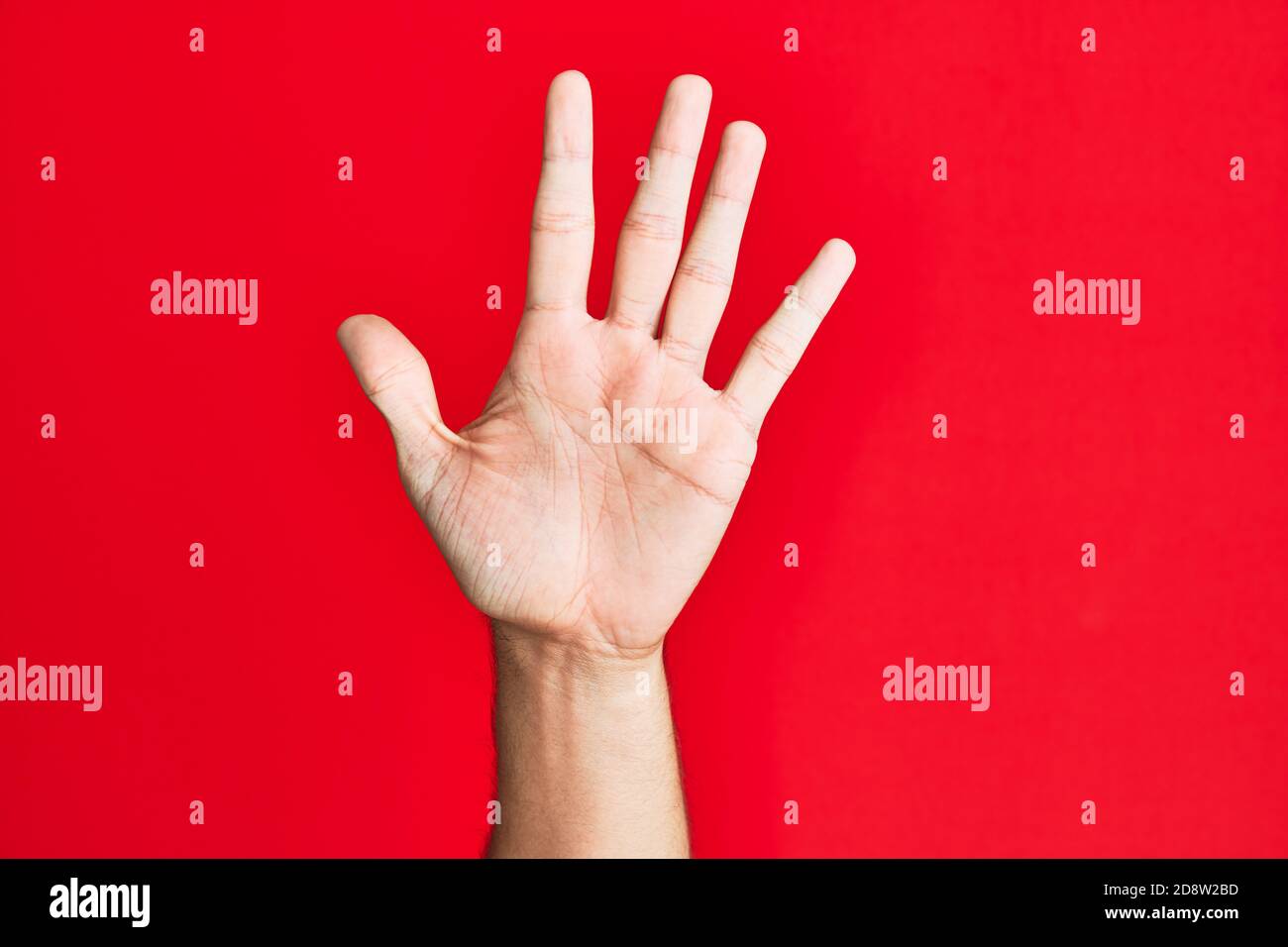 Arm of caucasian white young man over red isolated background counting ...