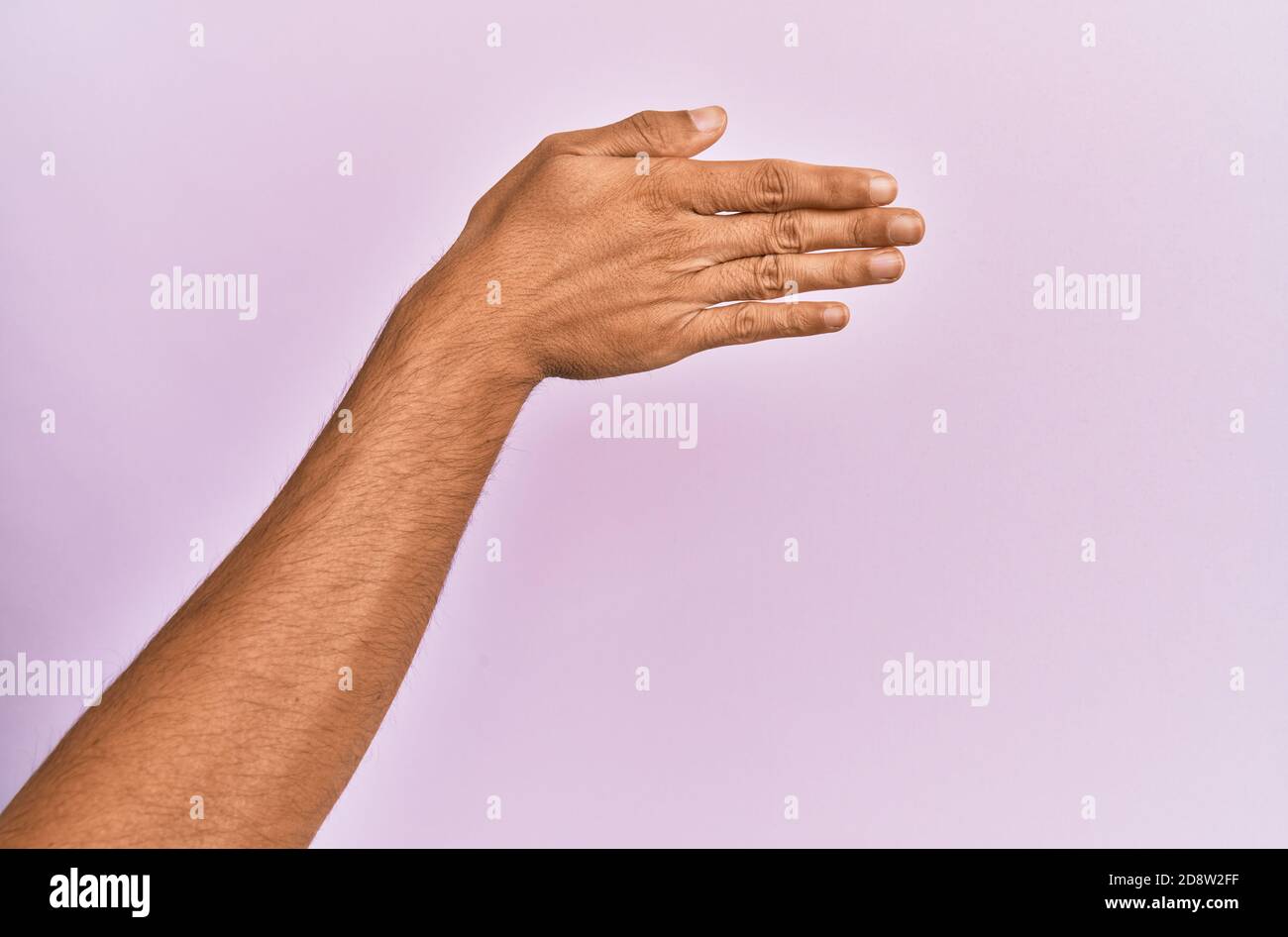 Arm and hand of caucasian young man over pink isolated background ...