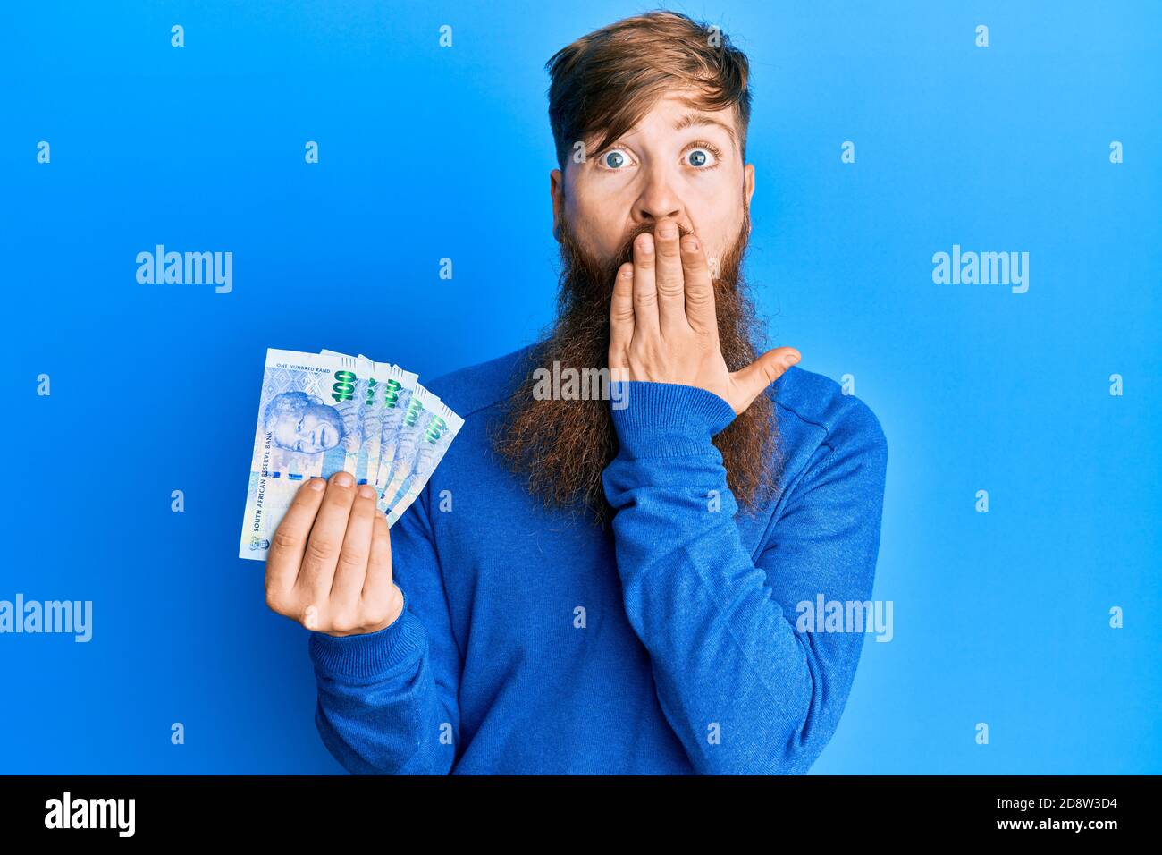 Young irish redhead man holding south african 100 rand banknotes ...