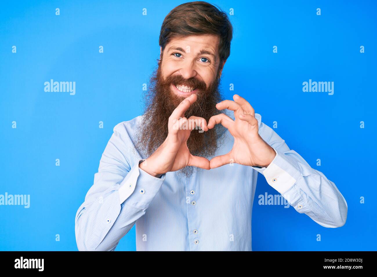 Handsome young red head man with long beard wearing elegant clothes ...