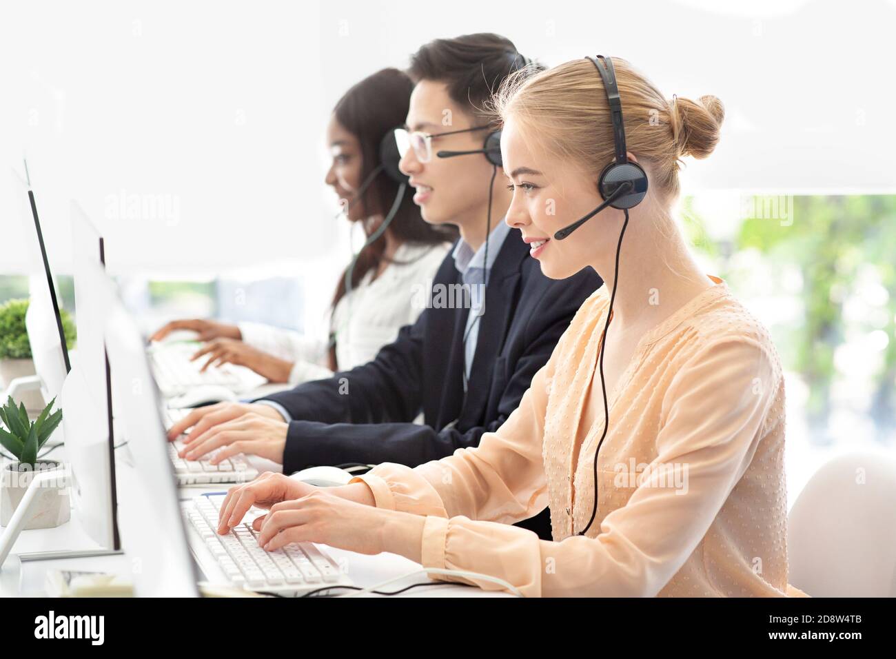 Team of hotline operators with headsets communicating to clients at ...