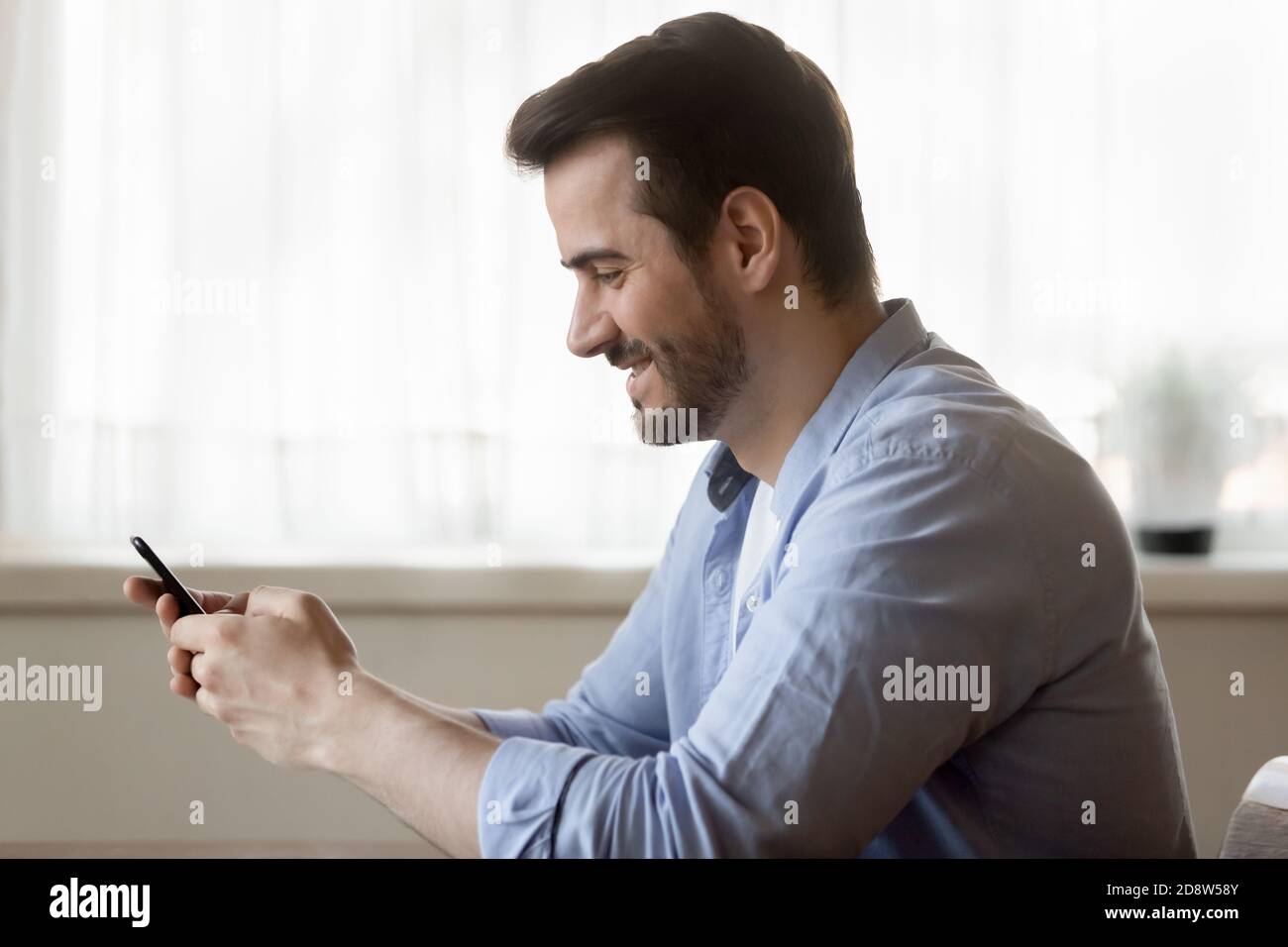 Happy smiling young man making call by smartphone Stock Photo - Alamy