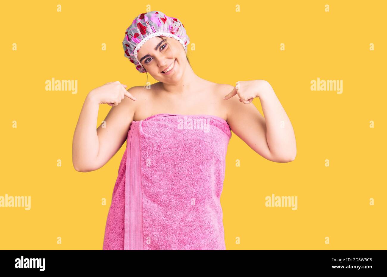 Young caucasian woman wearing shower cap and towel looking confident ...