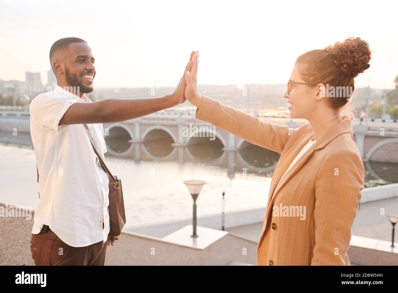 Smiling business partners of various ethnicities giving one another ...