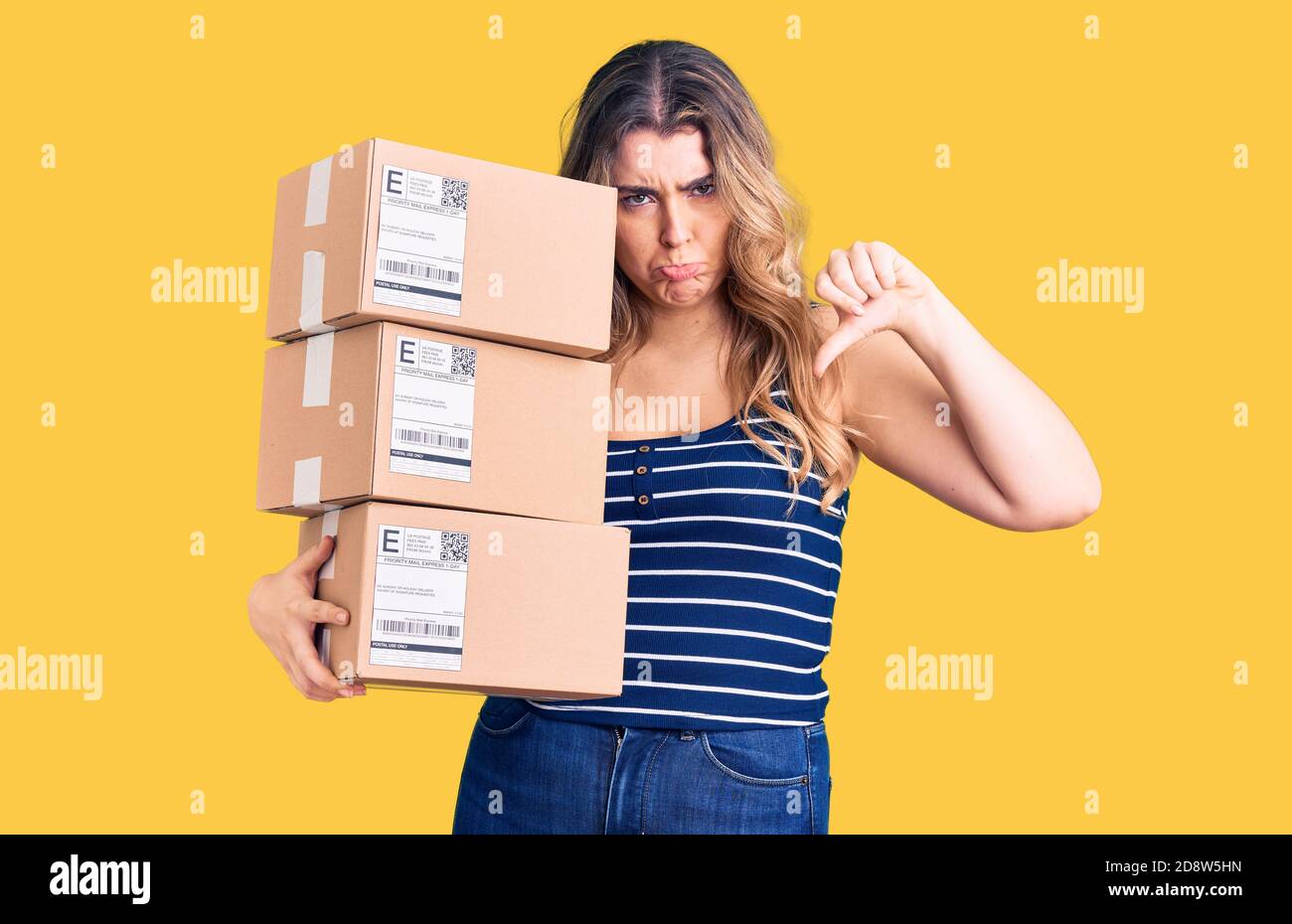 Young caucasian woman holding delivery package with angry face ...