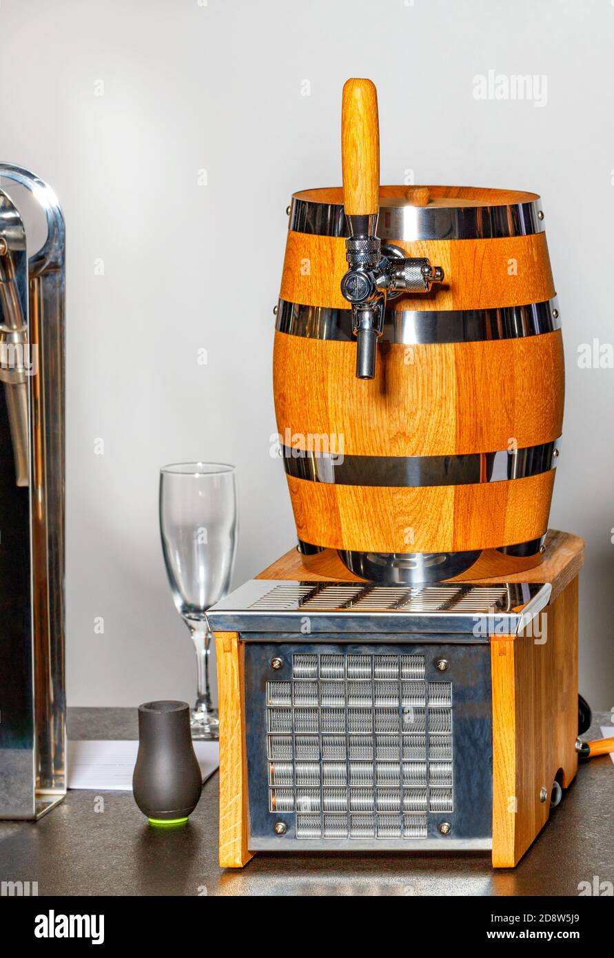 A new clean oak wooden barrel on the counter with a glass wine glass in ...