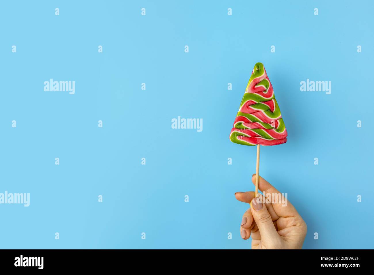 Woman hand hold tasty candies on on blue background. Candy shapes ...