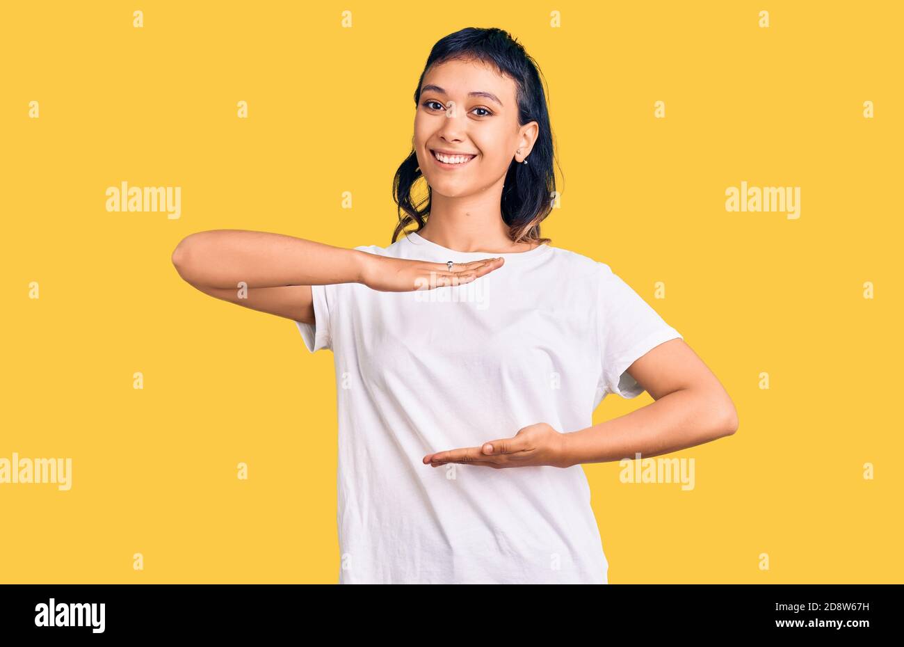 Young woman wearing casual clothes gesturing with hands showing big and ...