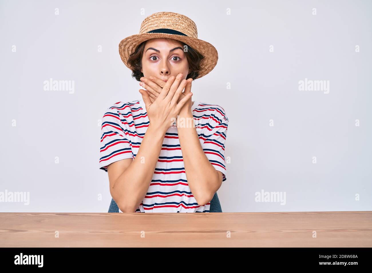 Young hispanic woman wearing casual clothes and hat sitting on the ...