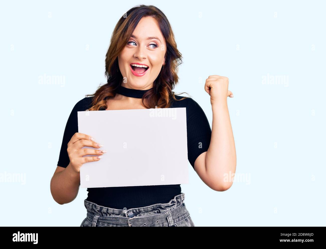 Young beautiful caucasian woman holding blank empty paper pointing ...