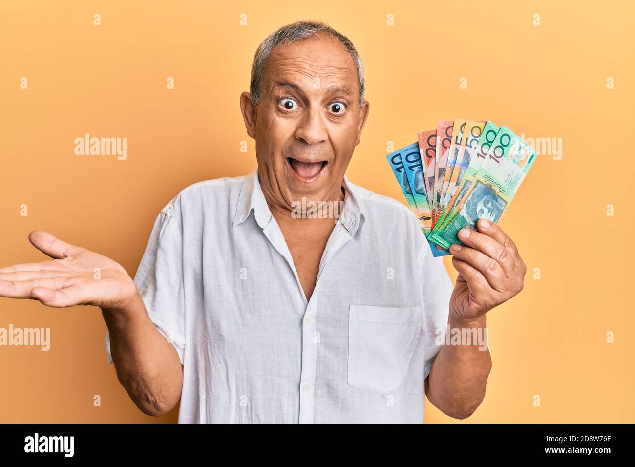 Handsome mature man holding australian dollars celebrating achievement ...