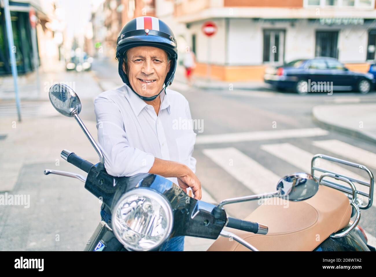 Senior motorcyclist man smiling happy wearing moto helmet at the city ...