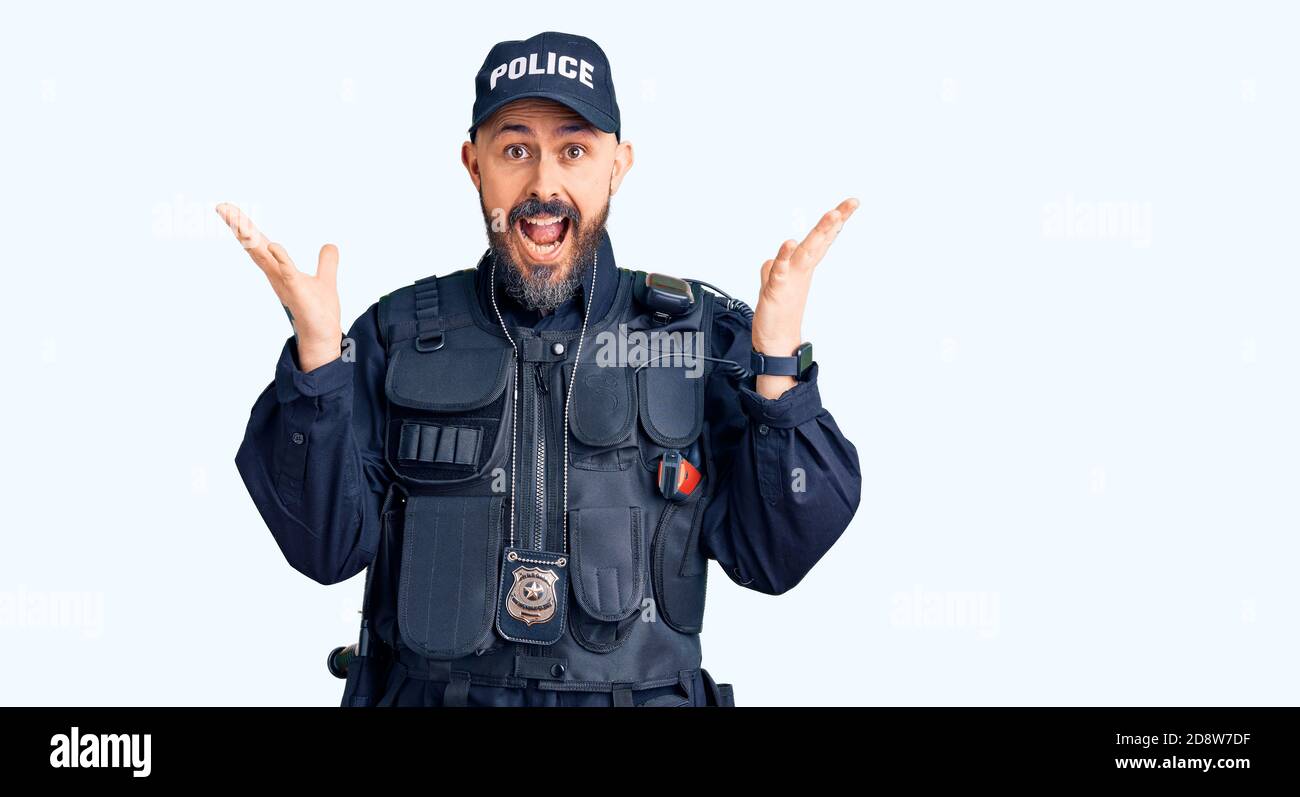 Young handsome man wearing police uniform celebrating crazy and amazed ...